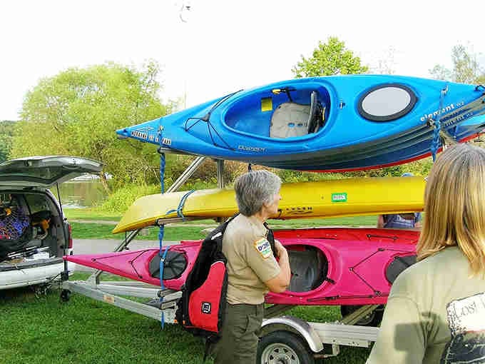 Kayaks stacked like a rainbow promise adventures that don't require a gym membership to enjoy.