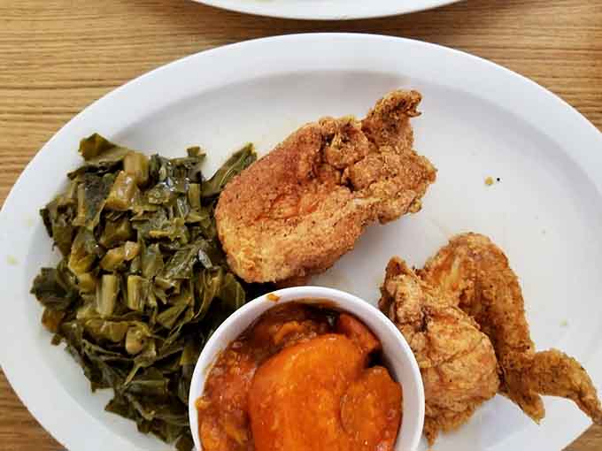 Golden perfection meets candied yams and collard greens in a plate that understands what comfort food really means.
