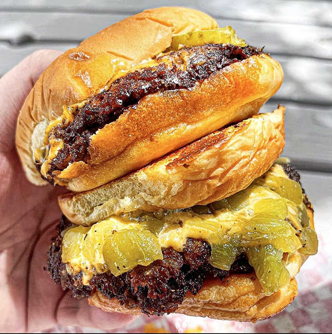 Two burgers stacked like edible skyscrapers, proving that more is definitely more when it comes to patties.
