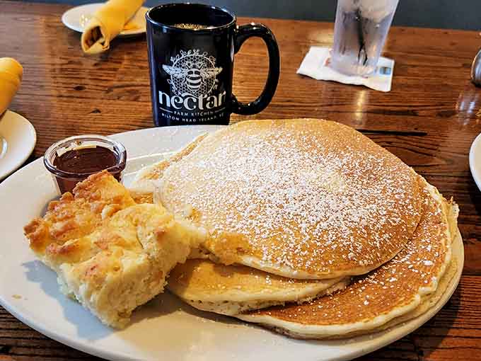 Fluffy pancakes dusted with powdered sugar, served with Nutella that'll make you question every breakfast choice you've ever made.