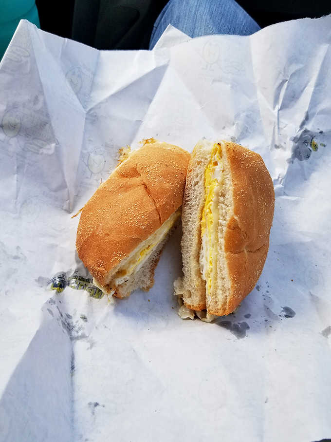 A breakfast sandwich so perfectly constructed it deserves its own engineering degree, nestled in a soft bagel embrace.