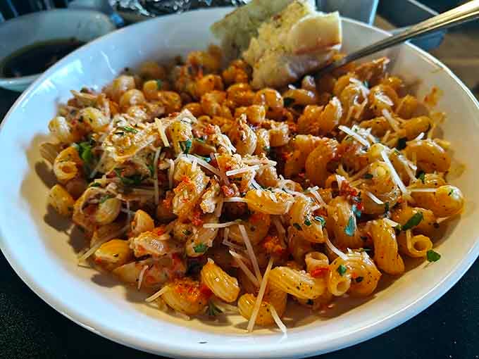 Pasta shells tossed with what appears to be a spicy tomato situation that'll make you forget every boring macaroni memory.