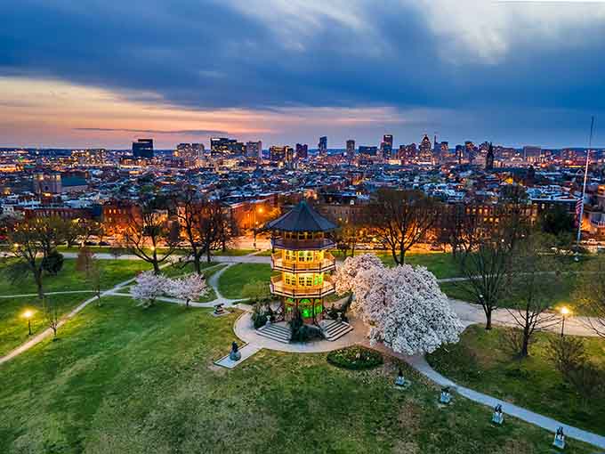 Twilight transforms the Pagoda into a glowing beacon, with cherry blossoms framing Baltimore's skyline beyond like a postcard come alive.