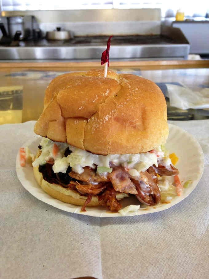 Pulled pork piled high with slaw creates the kind of sandwich that requires strategic planning and napkins.