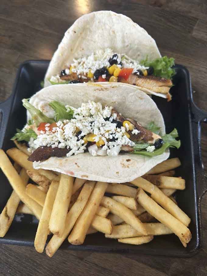 Fish tacos done right, with fries that understand their assignment and tortillas standing tall like edible architecture at its finest.