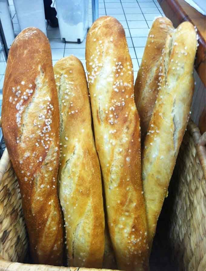 Fresh-baked baguettes with sea salt crystals catching the light, crusty and golden like Parisian dreams come true.