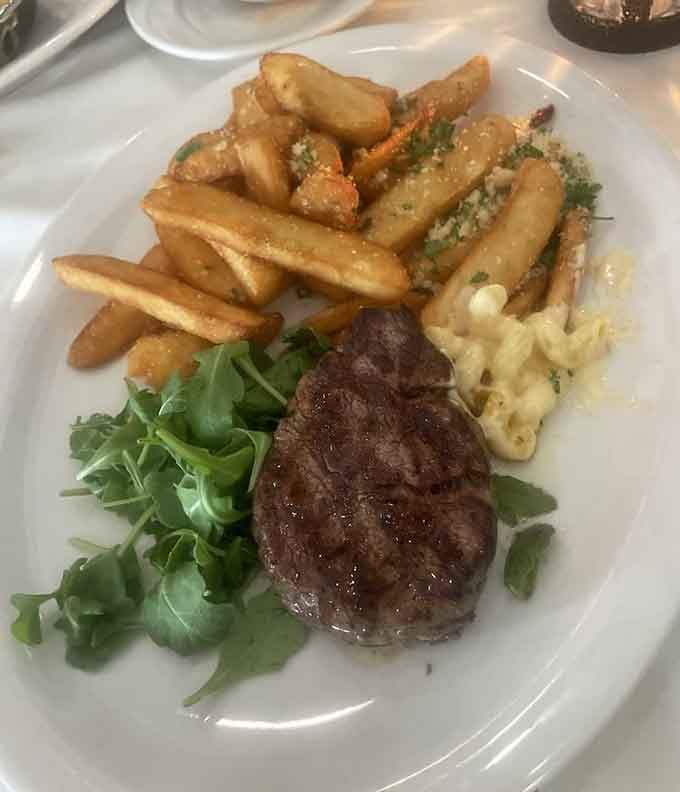 A beautifully plated filet with crispy fries and fresh arugula&mdash;simple elegance that lets quality ingredients shine through completely.