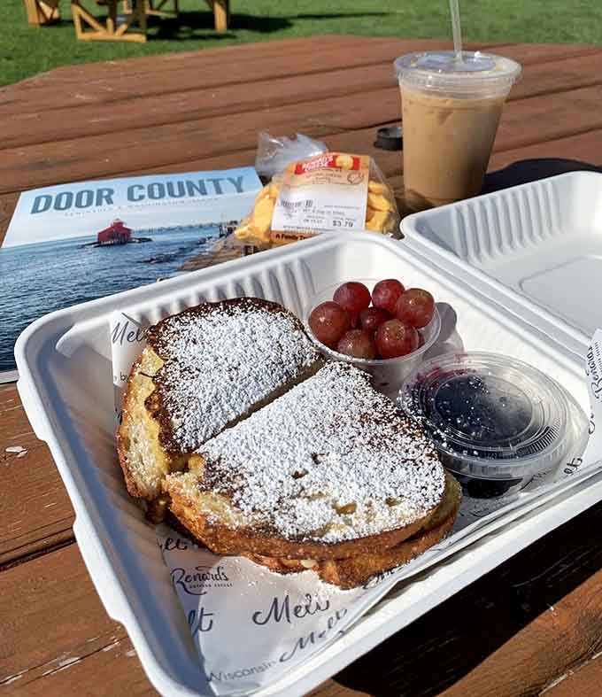 French toast dusted with powdered sugar alongside fresh grapes proves this deli menu goes beyond the expected cheese offerings.