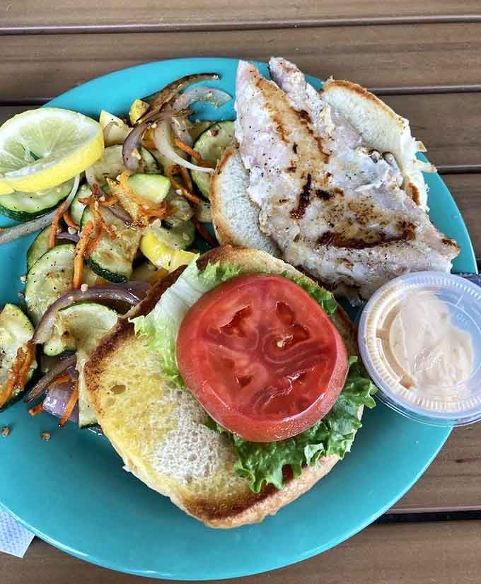 Grilled grouper sits majestically on a bun, proving that sometimes simplicity is the ultimate sophistication in seafood.