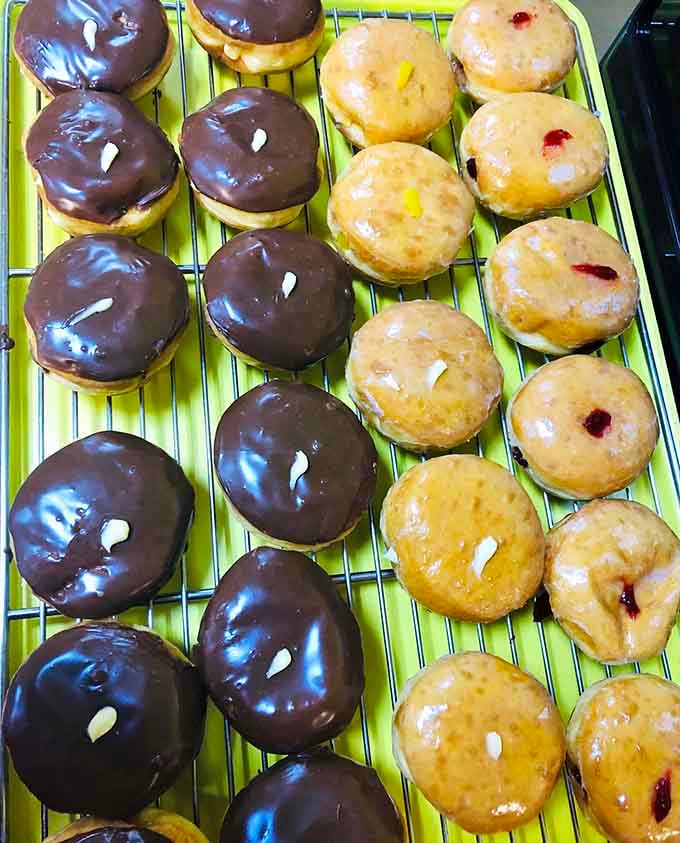 Boston cream and chocolate-glazed beauties lined up like edible works of art on their cooling rack.