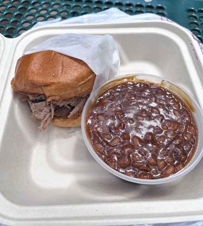 Pulled pork on a toasted bun paired with baked beans, because sometimes the simplest combinations create the most memorable moments.