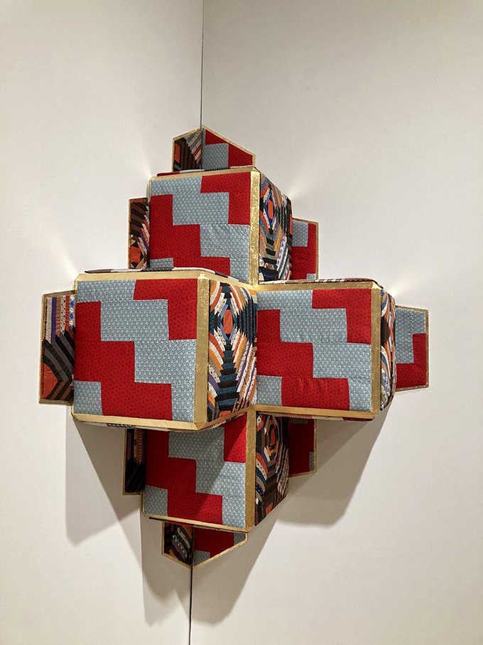 This geometric fabric sculpture looks like someone gift-wrapped the concept of infinity and hung it on the wall.