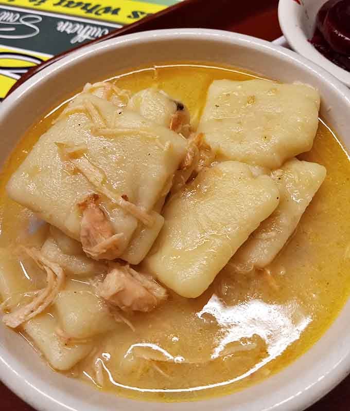 Chicken and dumplings swimming in golden broth, the kind of dish that wraps you in a warm hug.