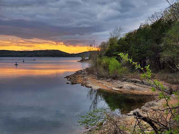 Golden hour transforms the lake into liquid amber, while distant fishermen chase their dinner in peaceful silence.
