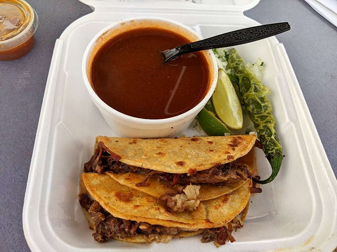 Crispy tacos stacked like edible architecture, accompanied by consomm&eacute; that'll warm your soul on any day.