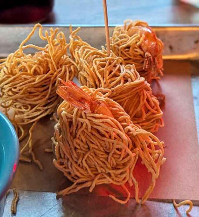 Crispy noodle nests cradling shrimp like edible treasure chests, because sometimes presentation matters as much as taste.