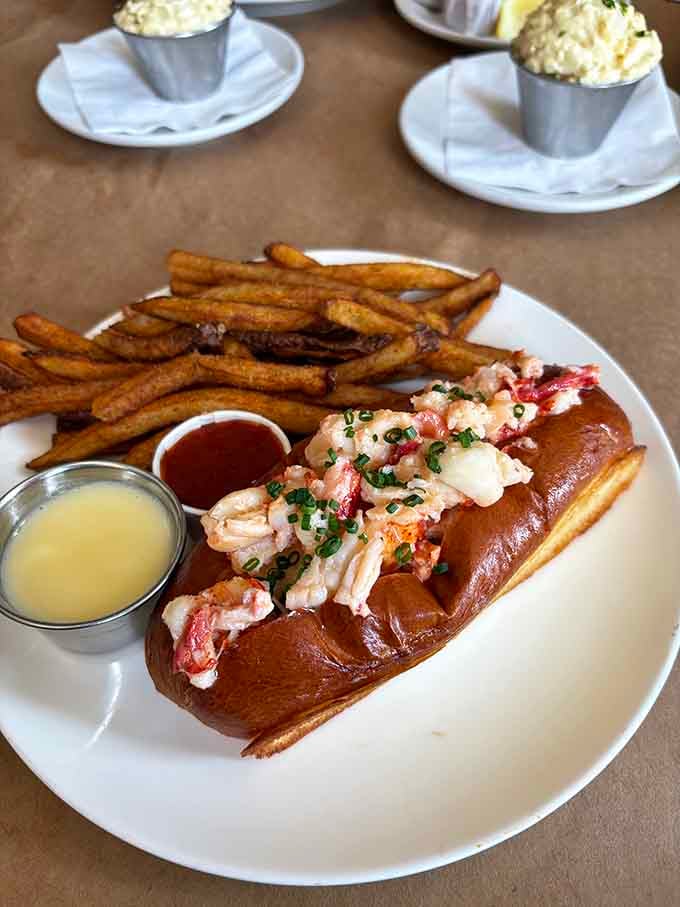 The lobster roll arrives like royalty, overflowing with sweet meat that makes you forget every sandwich you've ever eaten.