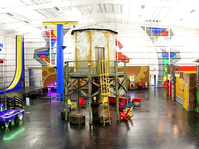 Industrial chic meets childhood dreams in this cavernous space where rusty water towers become whimsical climbing centerpieces.