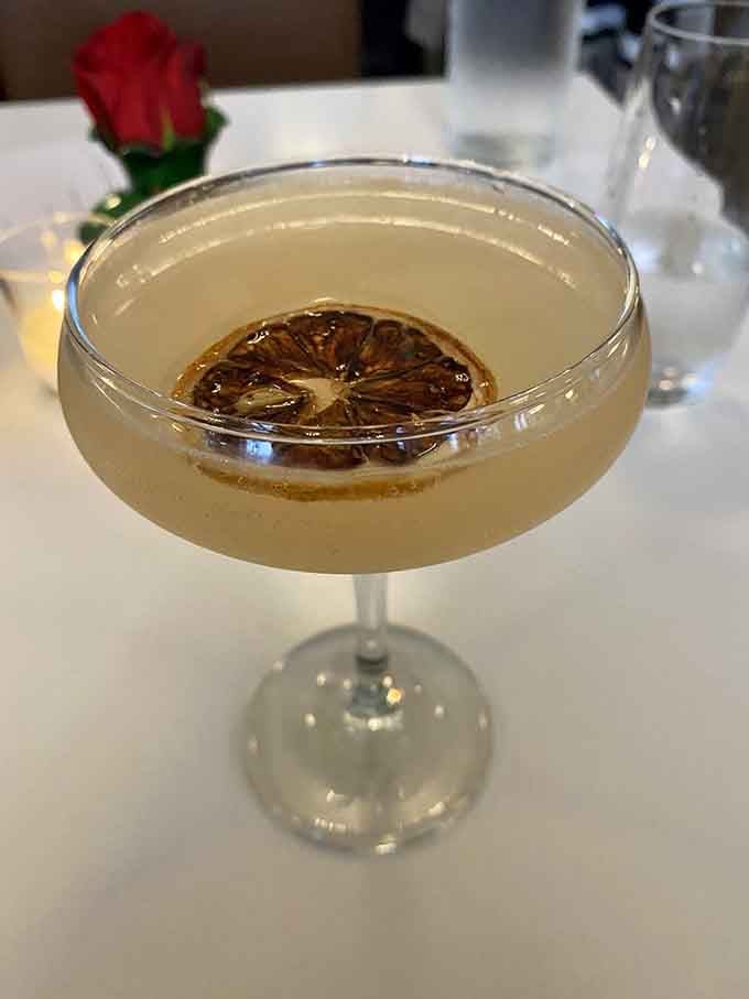 A craft cocktail garnished with a charred citrus wheel, because sometimes drinks deserve to be as photogenic as dessert.