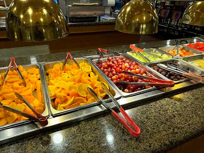 Fresh oranges and grapes glisten under the buffet lights, offering a virtuous pause between indulgent courses.