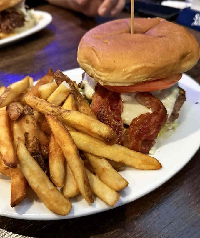 That toothpick is working harder than a suspension bridge, holding together layers of bacon, cheese, and pure joy.