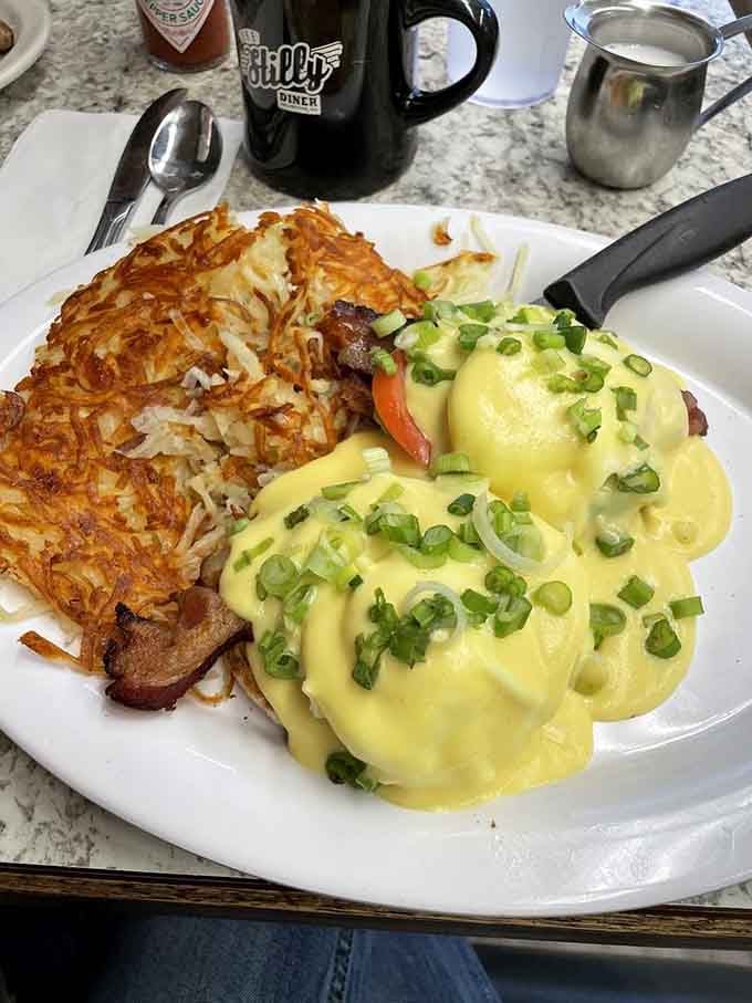 That hollandaise cascade over eggs benedict with fresh green onions is basically edible sunshine on a plate.