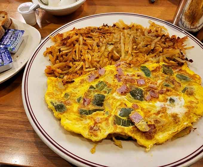 That omelet is stuffed so generously, it's practically bursting with ham, peppers, and pure breakfast joy.