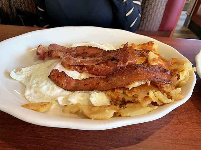 Crispy bacon draped over fluffy eggs and golden hash browns is the breakfast equivalent of a standing ovation.