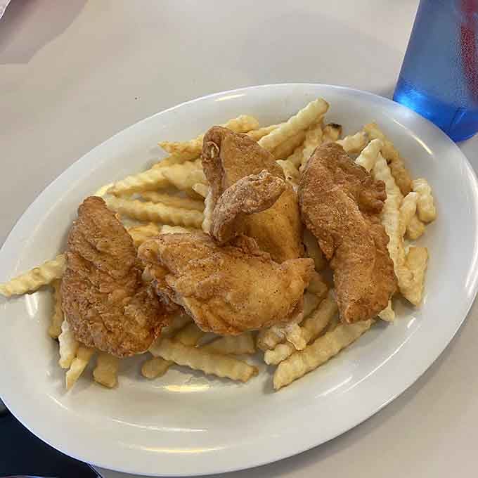 Golden chicken tenders atop a mountain of fries: simple, satisfying, and exactly what you're craving.