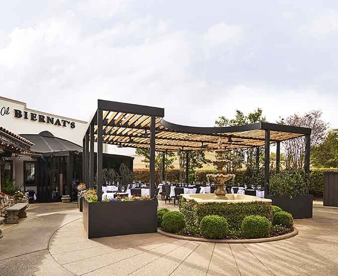 The modern pergola and manicured landscaping prove that outdoor dining can be both comfortable and absolutely stunning year-round.