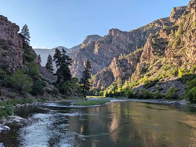 The Gunnison River carves through ancient rock far below, creating shadows so deep they inspired this canyon's mysterious name.