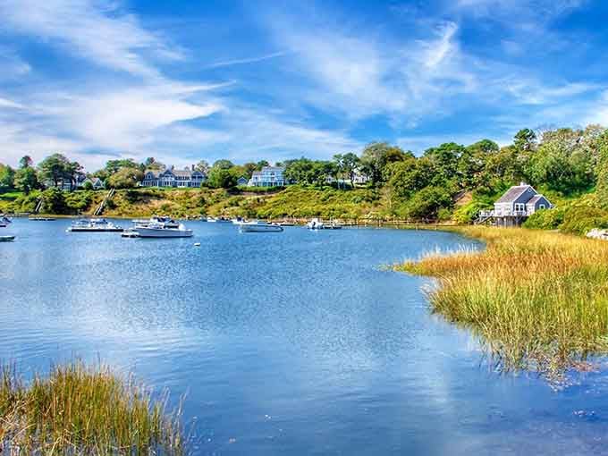 Golden marsh grasses frame peaceful waters where boats bob gently, reminding you that nature's clock runs slower here.