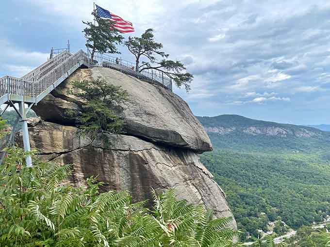 A flag waves from a rock outcrop that looks like nature's own aircraft carrier suspended in midair.