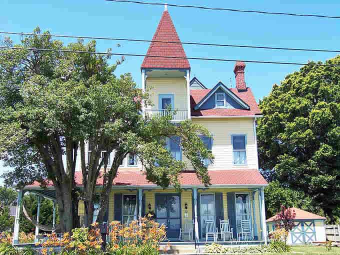 That turret and wraparound porch belong on a Victorian postcard, complete with rocking chairs for serious relaxation.