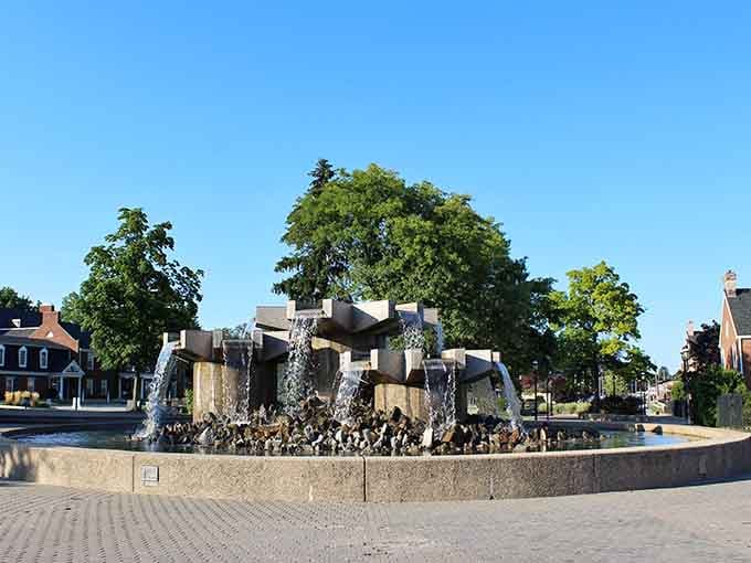 The fountain's modern sculpture catches sunlight and water, turning a simple plaza into something worth stopping to admire.