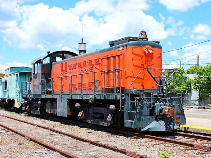 That bold orange New Haven locomotive practically glows against the blue sky like a sunset on wheels.