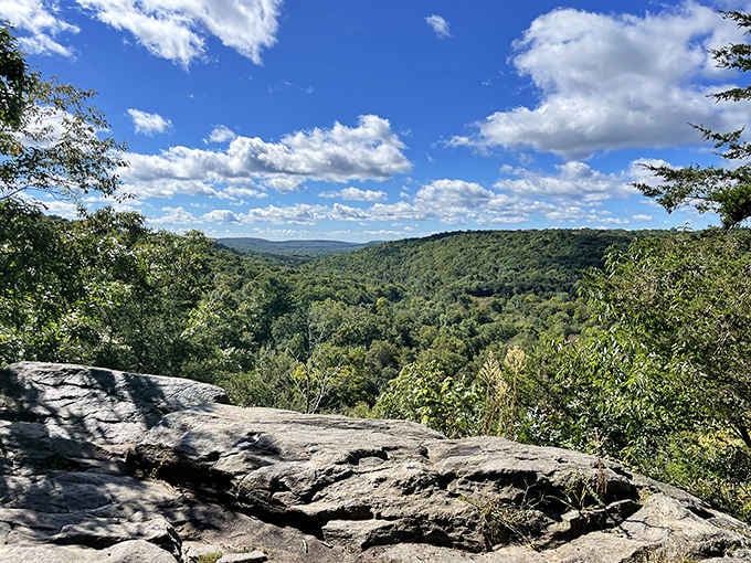 Rolling green hills stretch endlessly beneath puffy clouds, offering views that make the climb worthwhile.