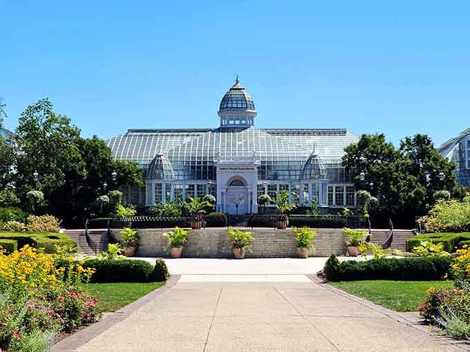 The grand glass conservatory gleams like a jewel, promising tropical escapes and botanical wonders inside.
