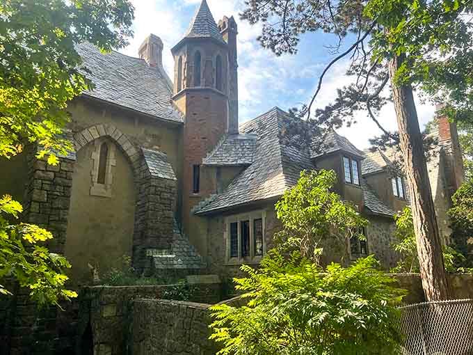 Medieval stonework and turrets peek through summer trees, creating an enchanting scene that feels wonderfully out of place.