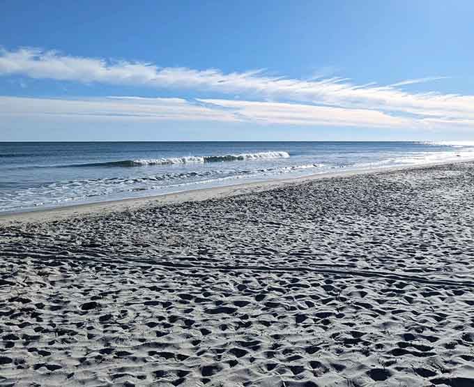 Miles of pristine shoreline stretch endlessly where gentle waves kiss sand in nature's most relaxing rhythm.