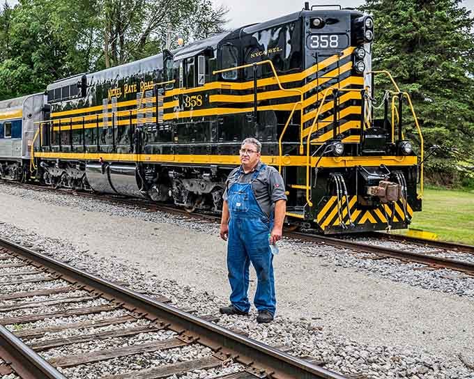 Those bold black and yellow stripes command attention while the friendly engineer stands ready for your journey ahead.