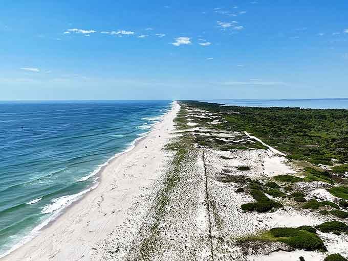 Ten miles of pristine coastline stretch endlessly—white sand dunes rolling like frozen waves under that brilliant blue sky.