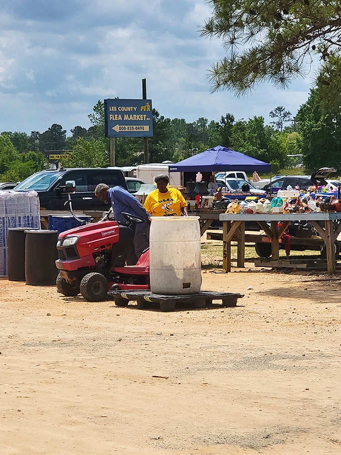 That red riding mower parked by wooden tables proves this market serves serious shoppers who come prepared for hauling.