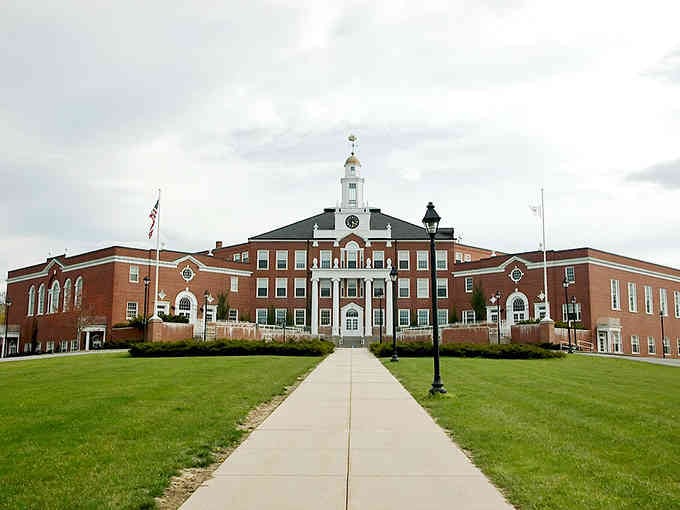 This grand brick building commands respect with its symmetrical design and manicured lawn stretching toward the entrance.