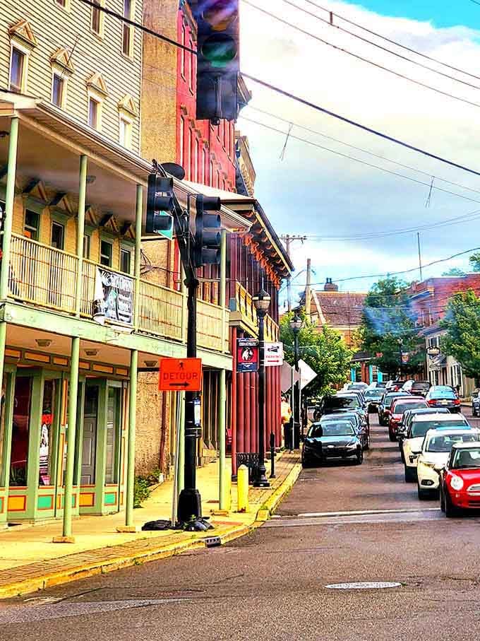 Colorful storefronts line this vibrant street where local businesses still flourish and parking spots actually exist for customers.