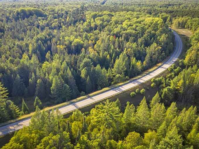 This ribbon of asphalt cuts through endless green forest like nature's own highway to heaven.