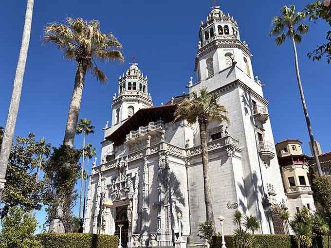 Hearst Castle's Mediterranean architecture rises above palm trees blending Old World elegance with California coastal beauty perfectly.