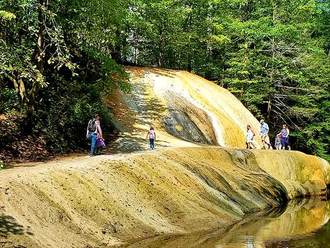 This golden rock formation creates a natural waterslide that's been polished smooth by countless years of flowing water.