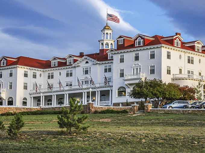 This grand white hotel with its red roof commands the hillside like a stately ship anchored in time.
