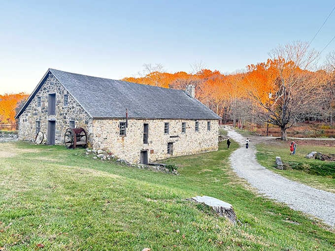 Stone mill buildings glow golden in autumn light, their weathered walls holding stories from America's industrial past beautifully.